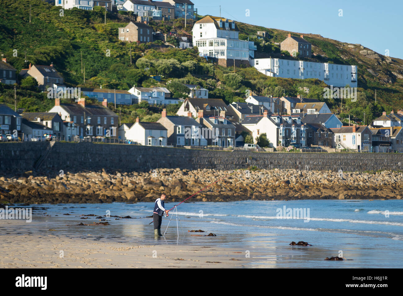 Fisherman on the beach of Sennen Cove in front of the houses of the ...