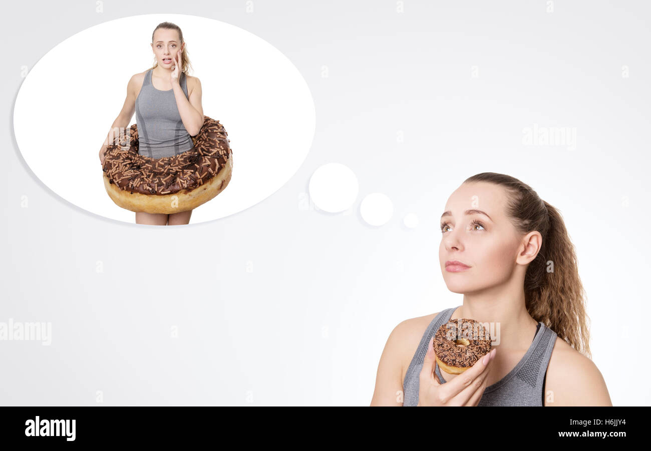 concept idea of a woman about to eat a donut but thinking she shouldn't ...