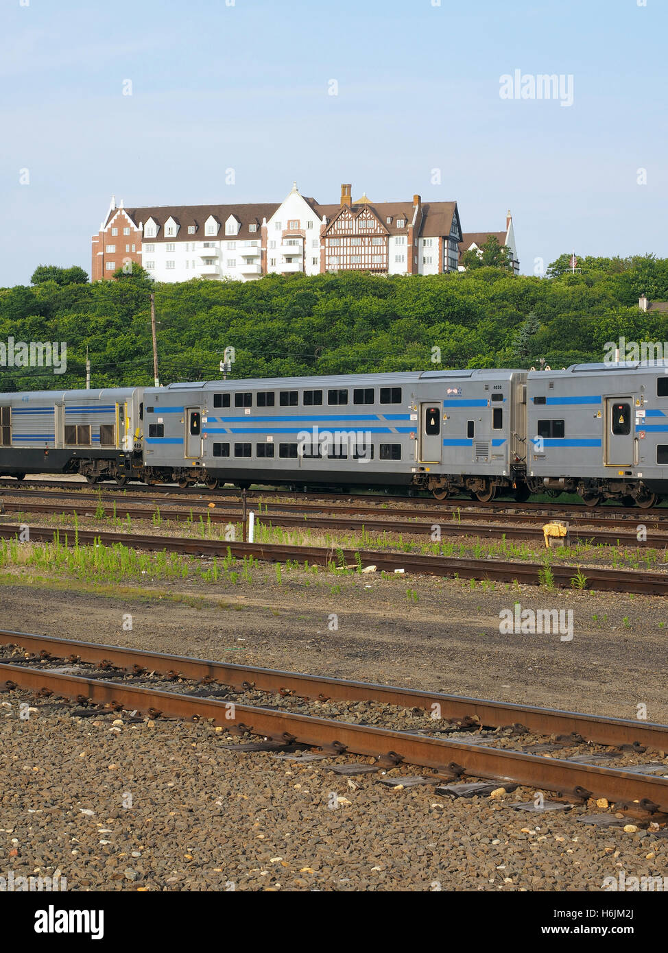 double decker commuter train on tracks under historic manor hotel on ...
