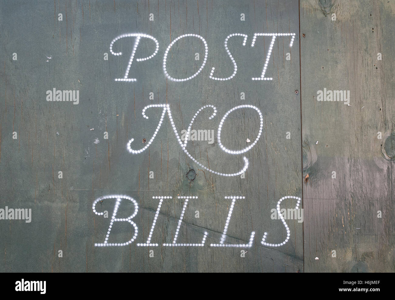 Post No Bills written on green wooden boarding around a construction ...