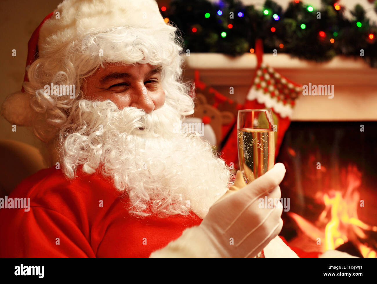 Santa Claus with glass of sparkling wine champagne near a Christmas ...
