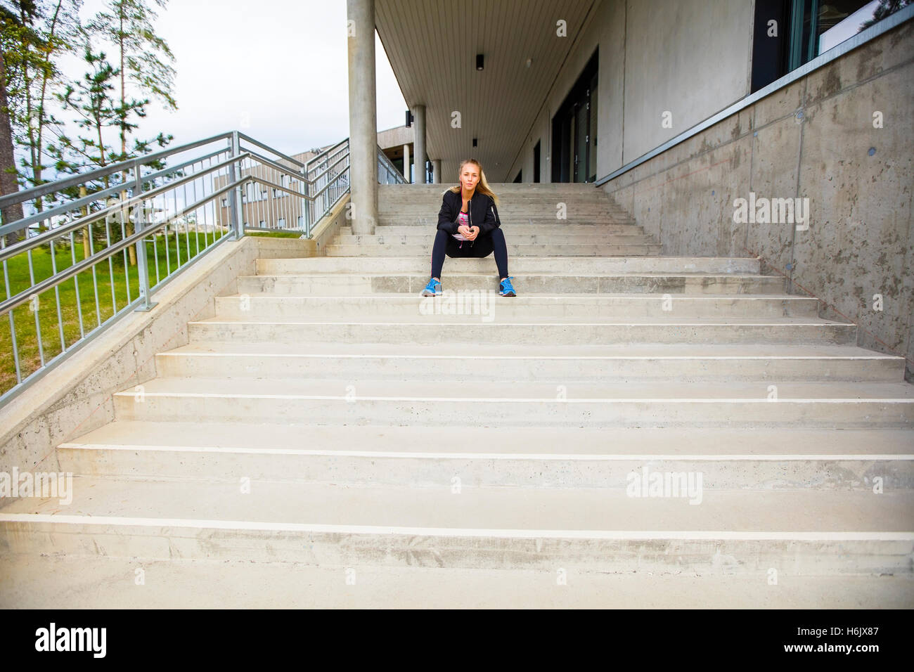 Sporty Young Woman Sitting On Steps After Workout Stock Photo - Alamy