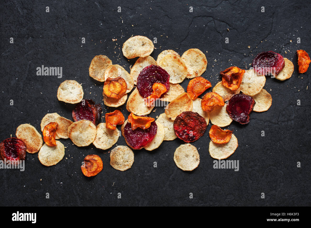 Homemade vegetable chips on the black table Stock Photo - Alamy