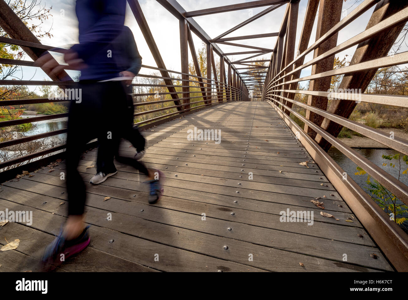 Runners cross a foot bridge in the fall Stock Photo - Alamy