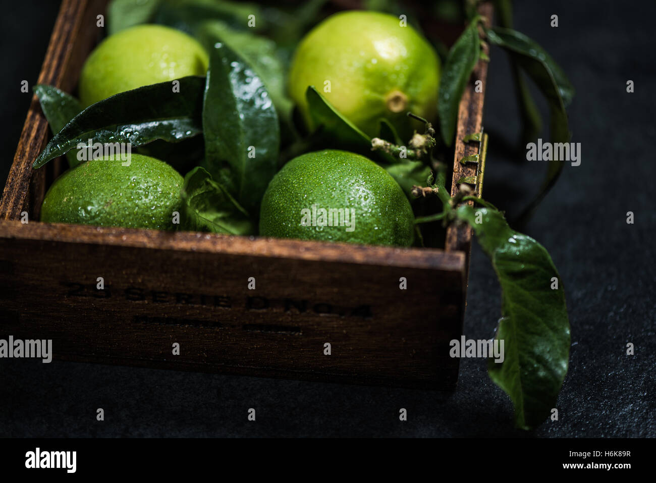 ripe lime fruit in wooden crate with leaves Stock Photo - Alamy