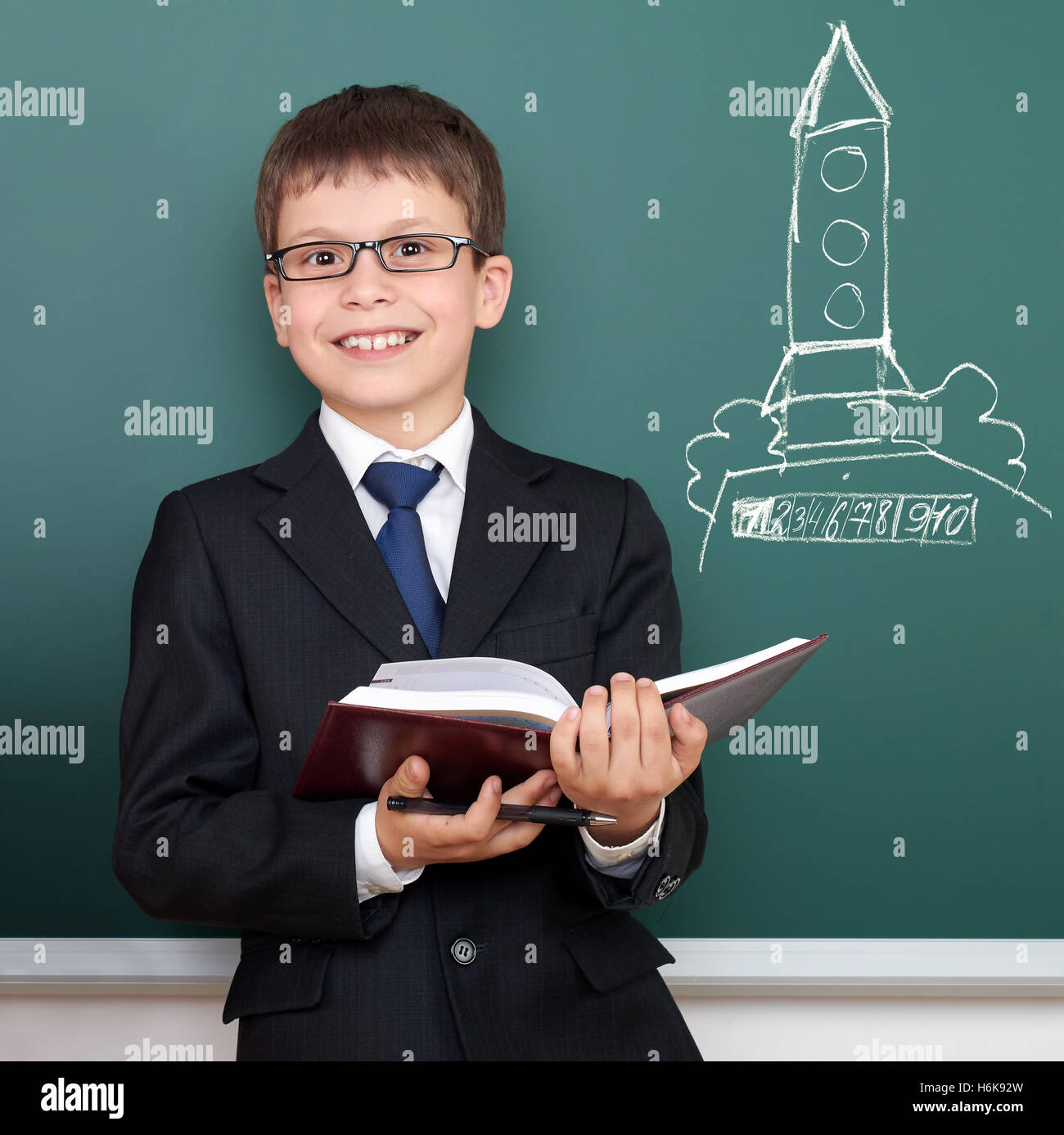 school boy with book, space rocket launch drawing on chalkboard ...