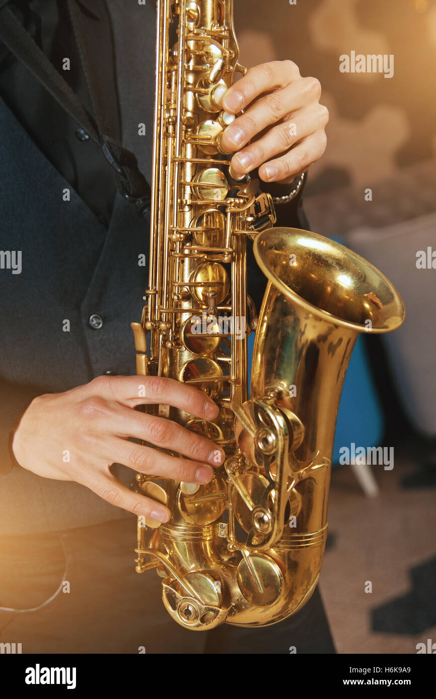Young man in a suit hold saxophone Stock Photo - Alamy