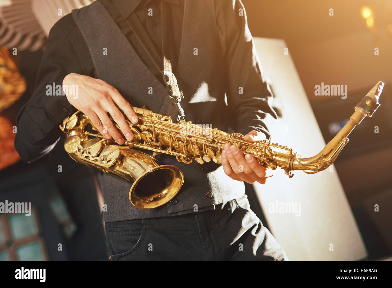 Young man in a suit hold saxophone Stock Photo - Alamy