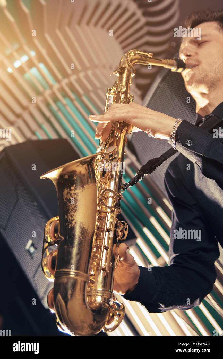 Young man in a suit hold saxophone Stock Photo - Alamy