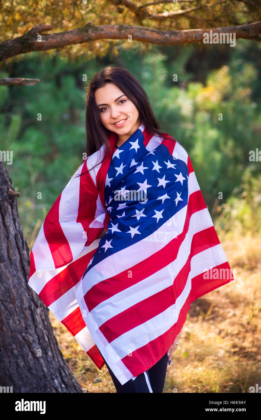 Beautiful model poses with the flag of the USA in the summer park Stock ...