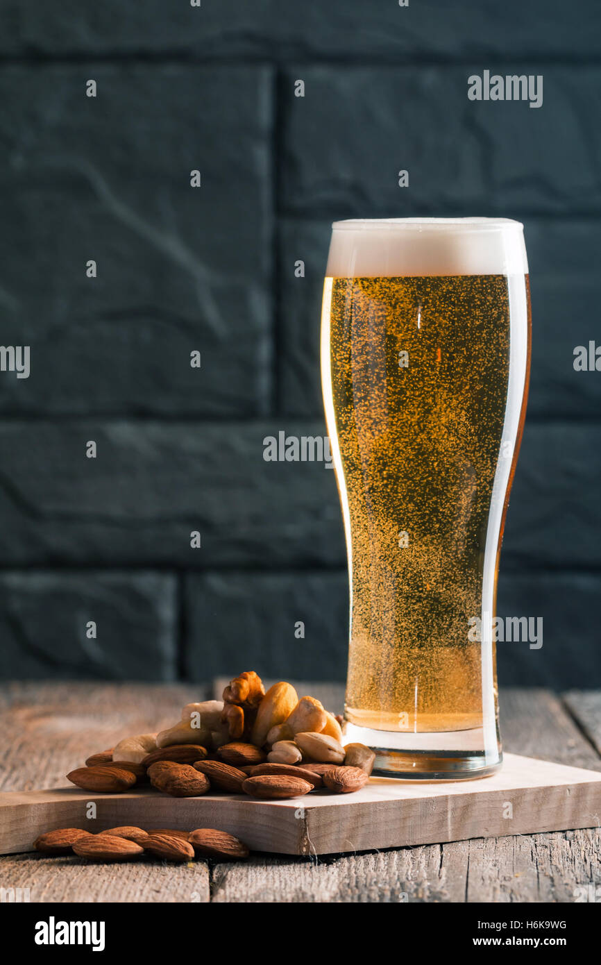 Glass of light beer with bubbles near black wall Stock Photo - Alamy