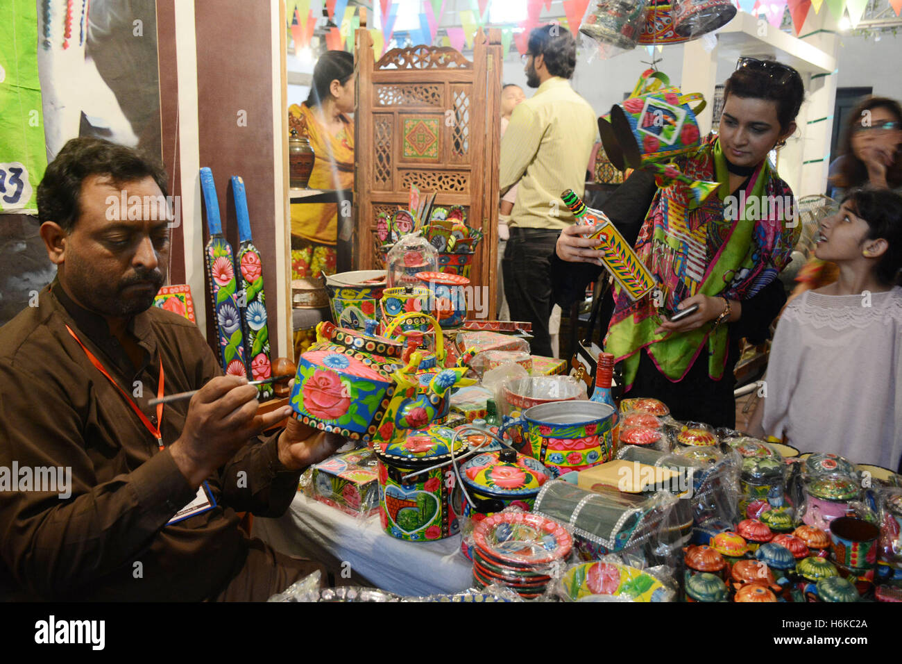 Lahore. 30th Oct, 2016. A Pakistani artist paints at his stall during ...