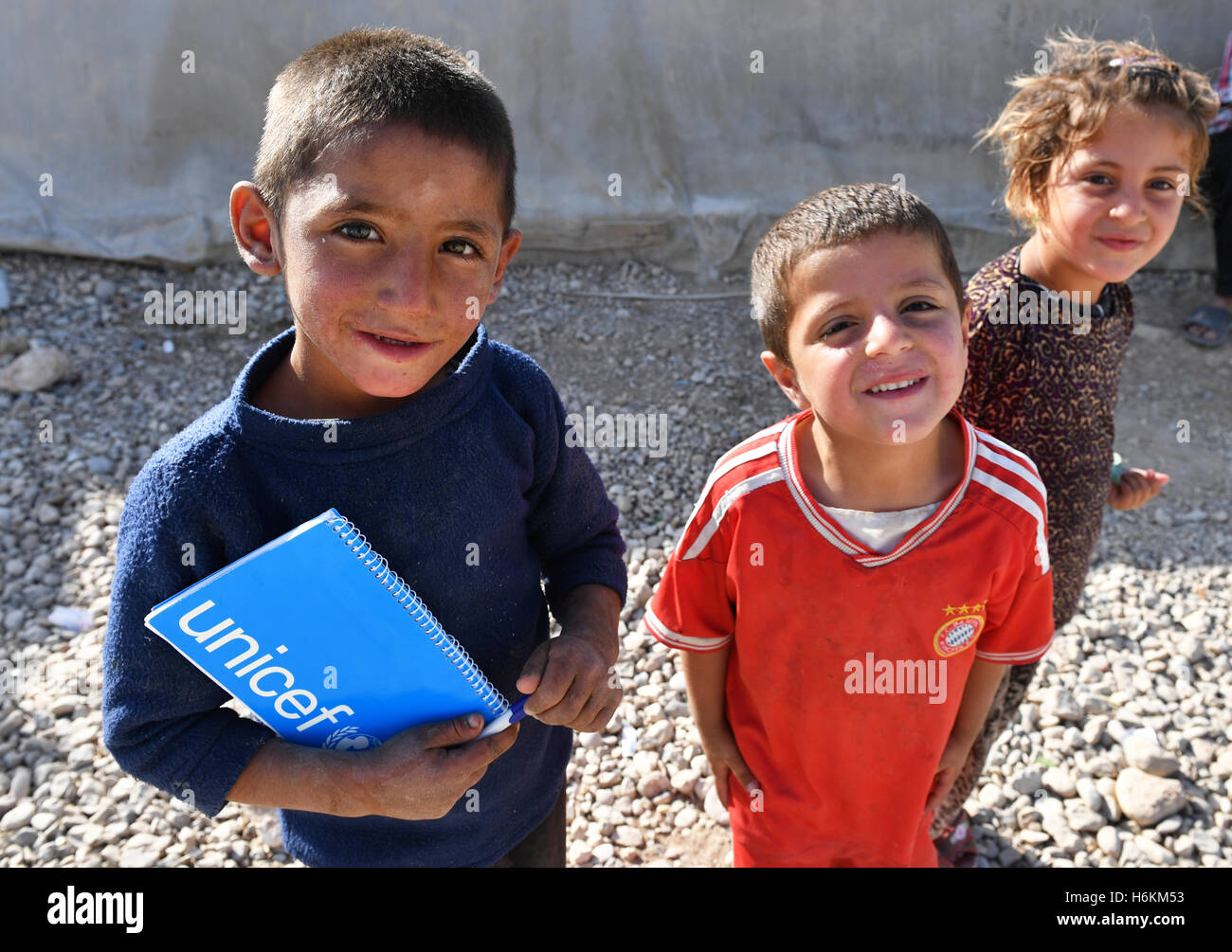 Refugee children stans with a UNICEF notepad in the Mamilian refugee ...