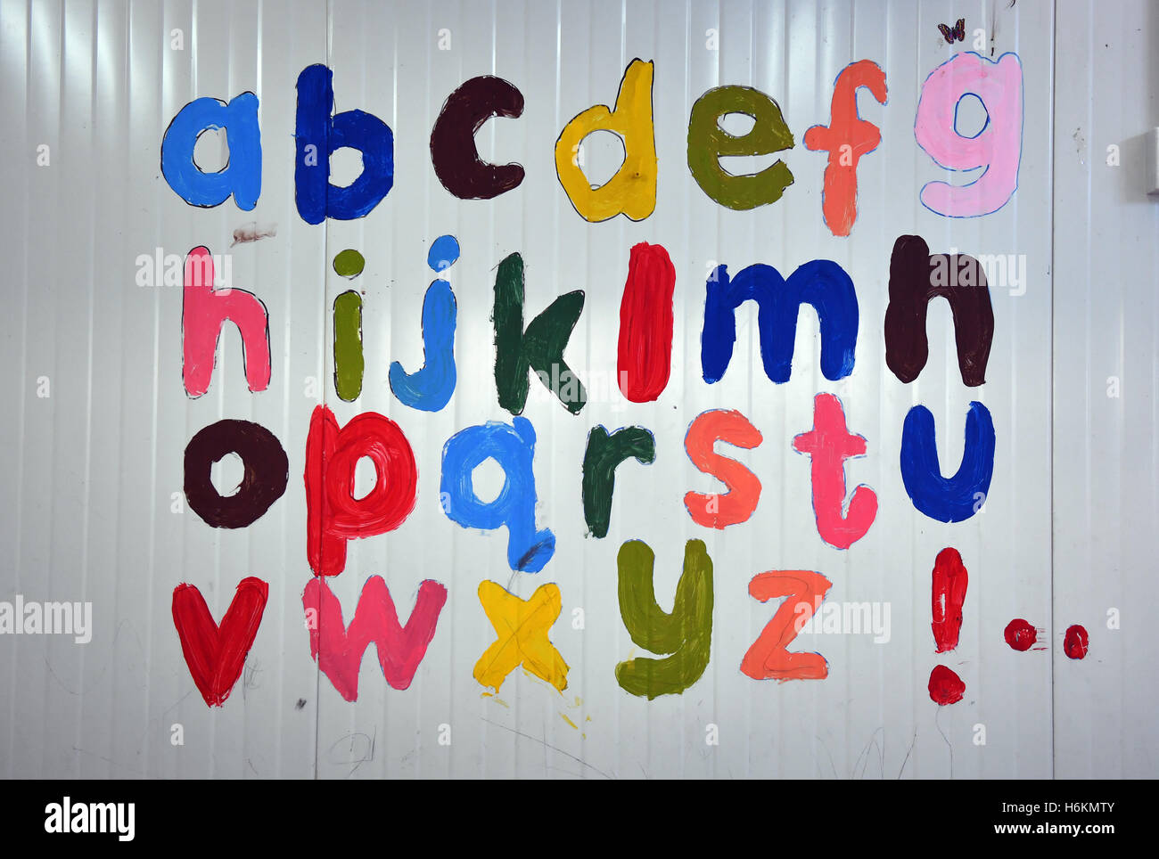The letters of the alaphet are written in bright colors on a wall in a ...