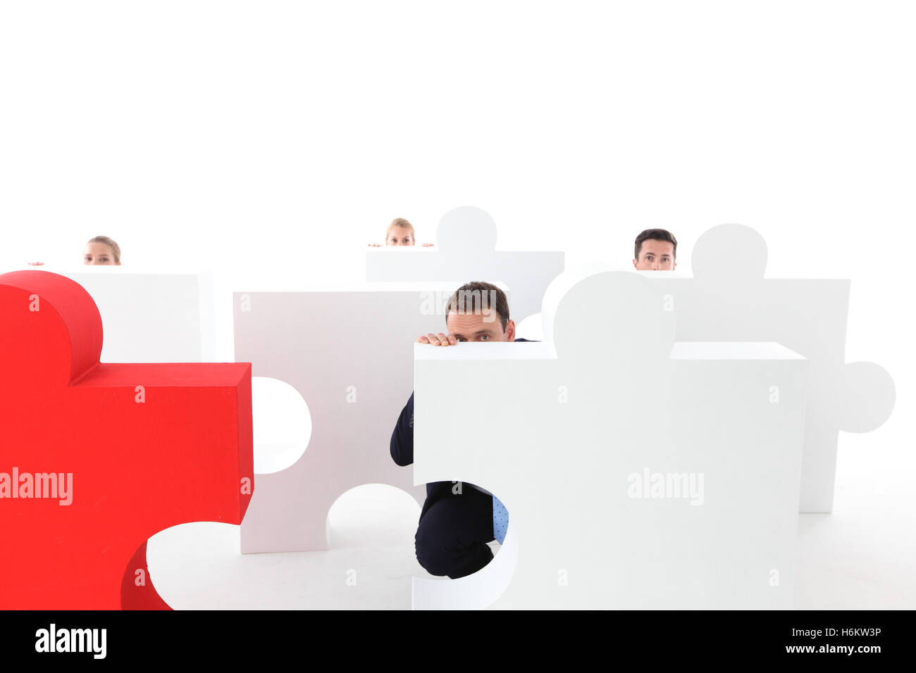 Business people hiding behind puzzle pices Stock Photo - Alamy