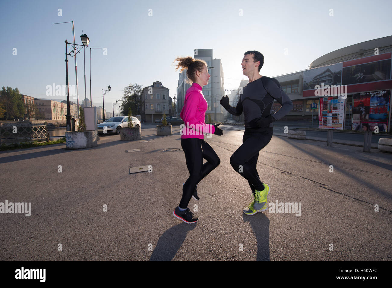 jogging couple warming up and stretching before morning running in the ...