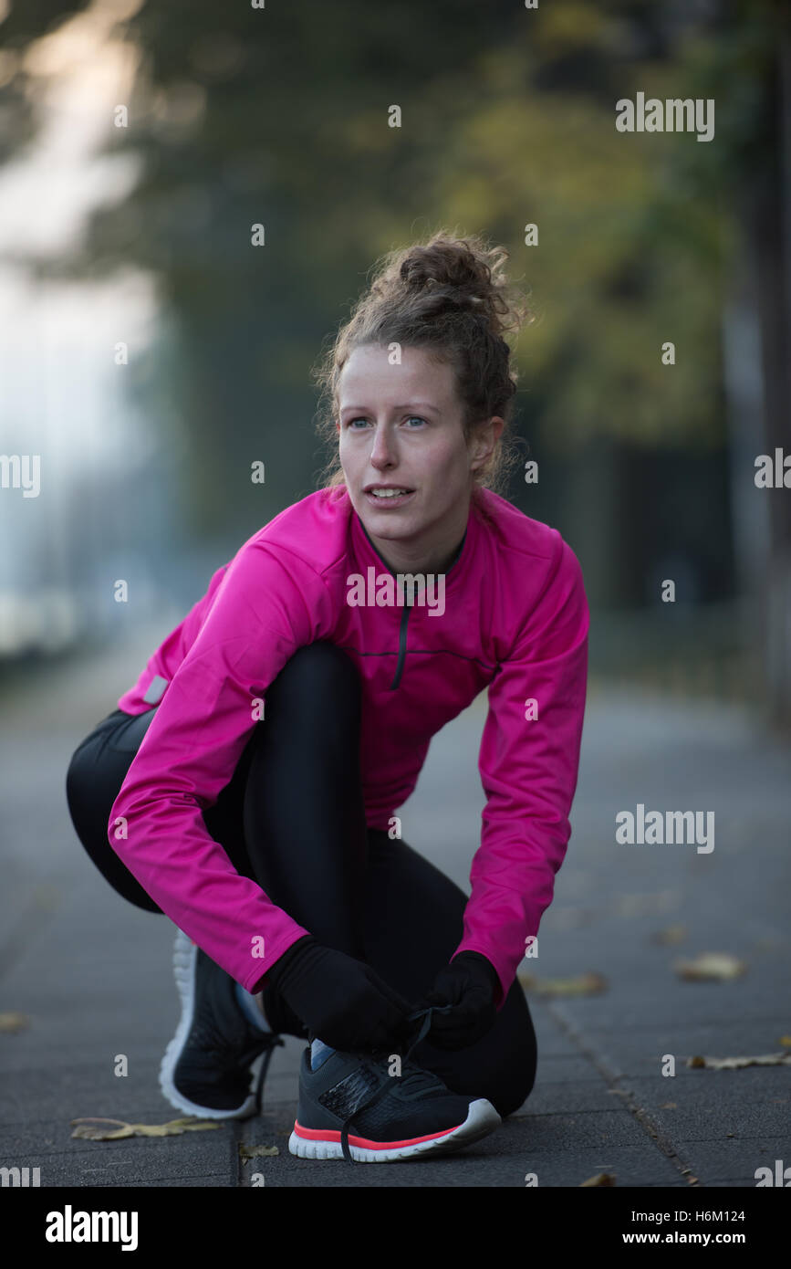 runner woman warming up and stretching before morning jogging Stock ...