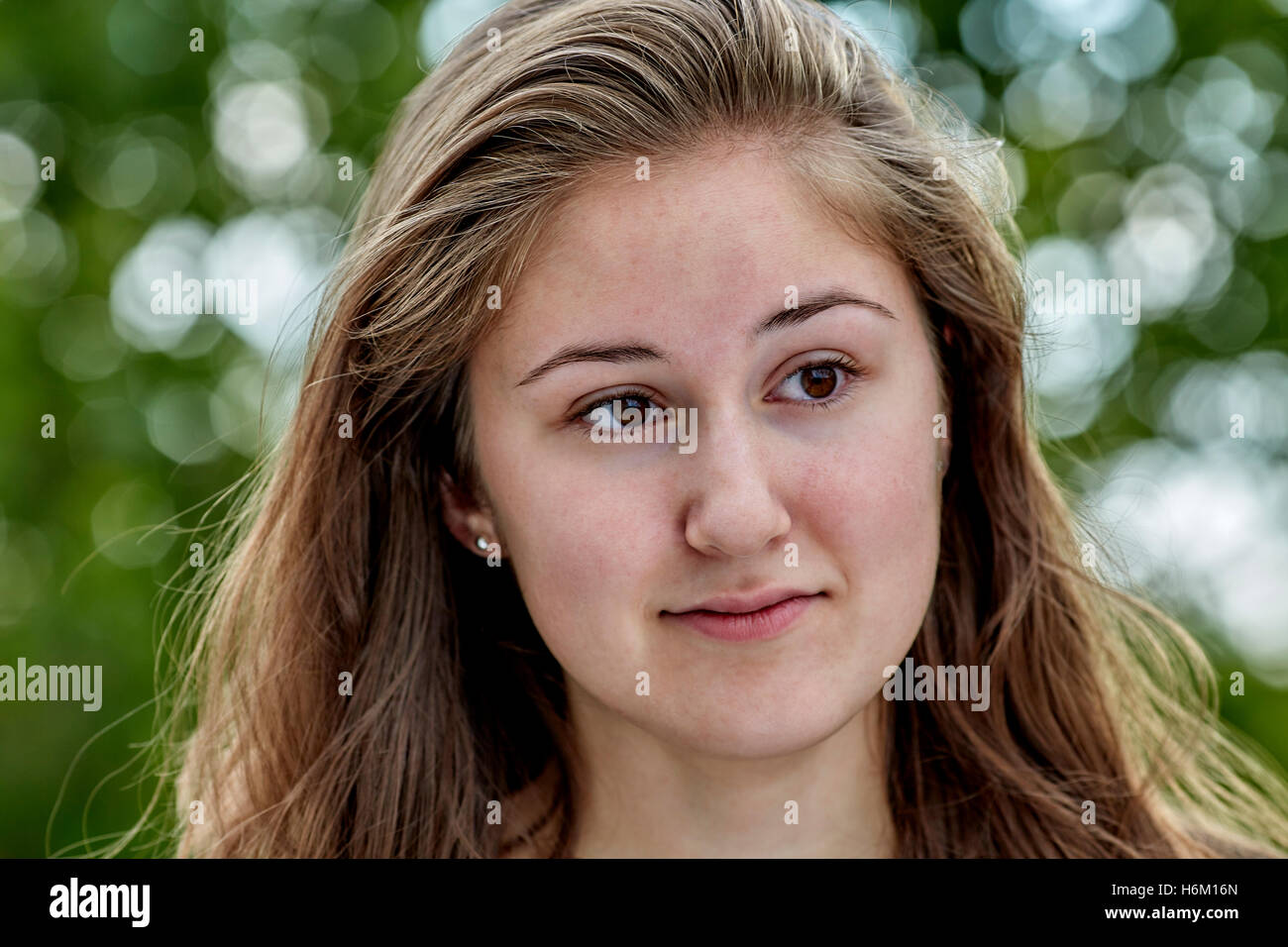 Young Woman expressing contemplation with a smile Stock Photo - Alamy