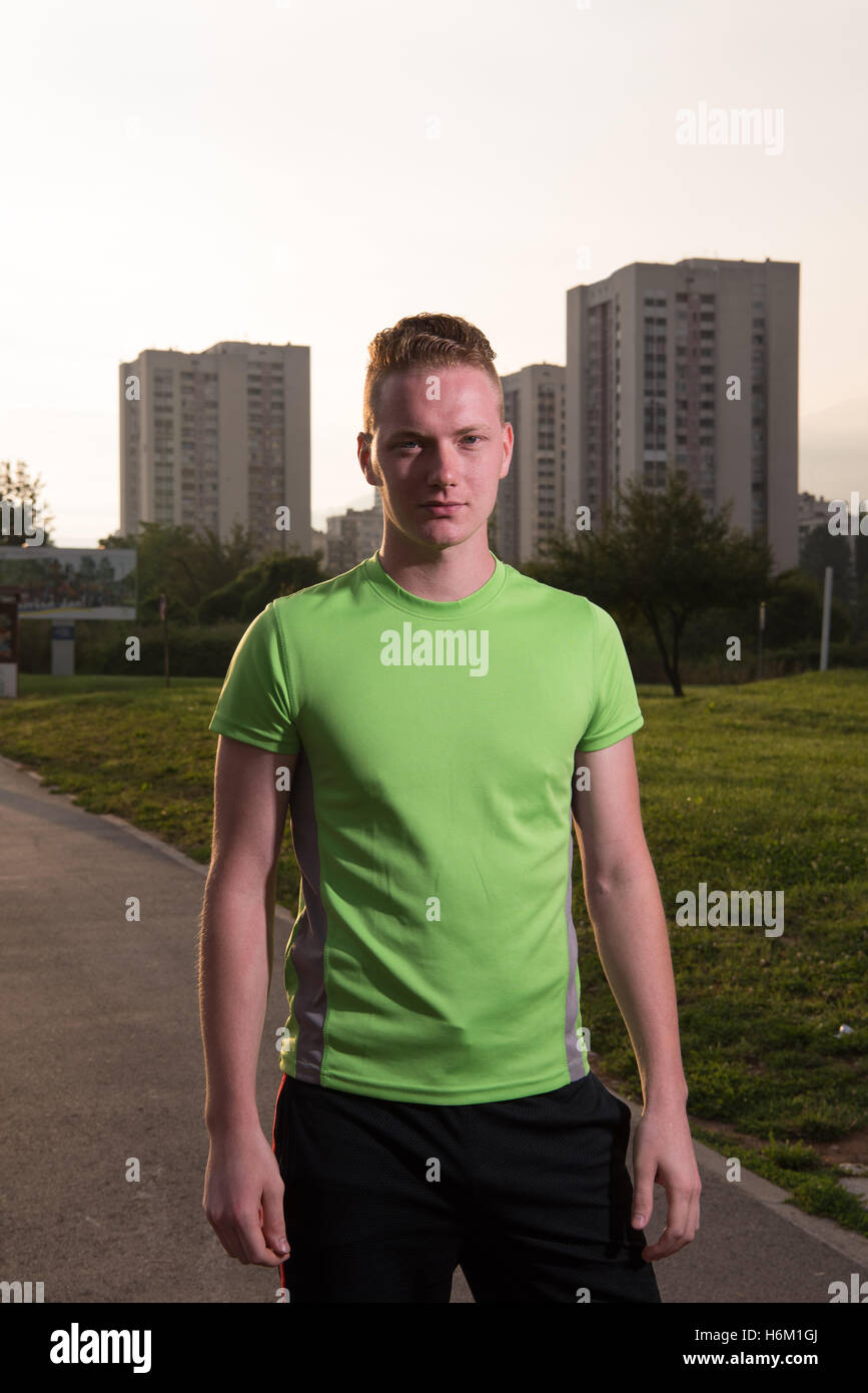 Young man looking at the rest of path during a break of his outdoor ...