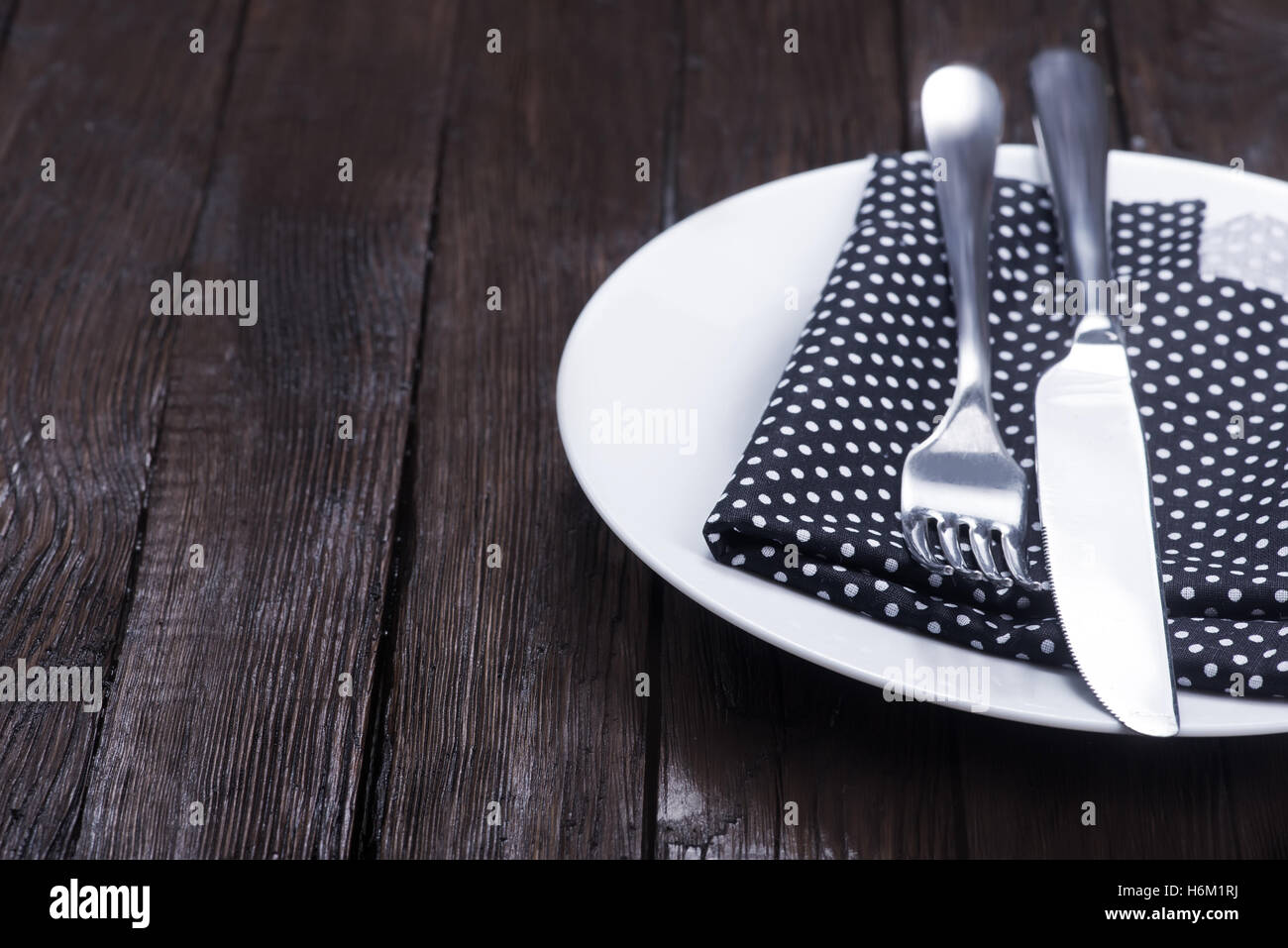 Dishes in kitchen. Knife, spoon and fork with serviette over dish Stock ...