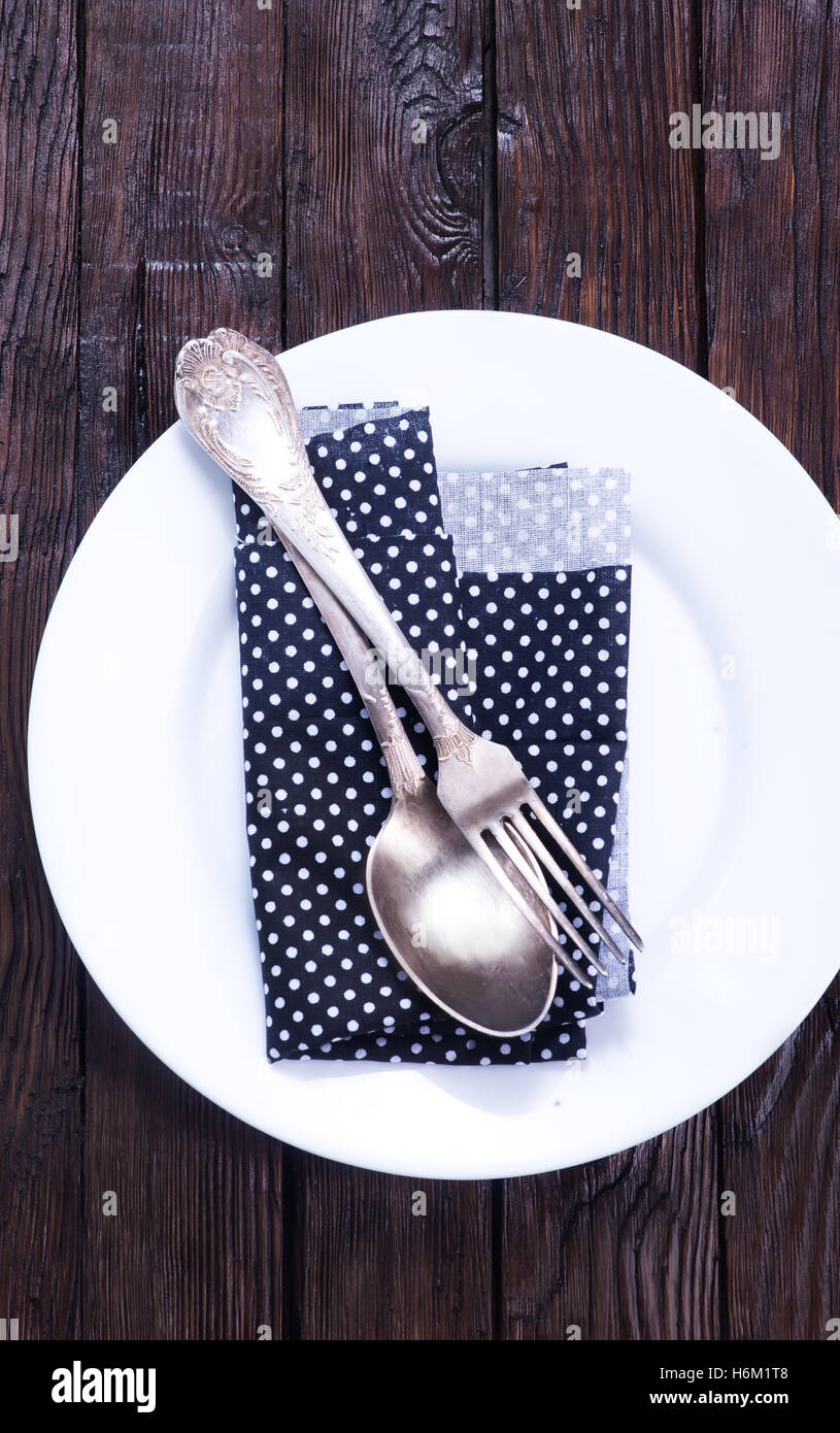 Dishes in kitchen. Knife, spoon and fork with serviette over dish Stock ...