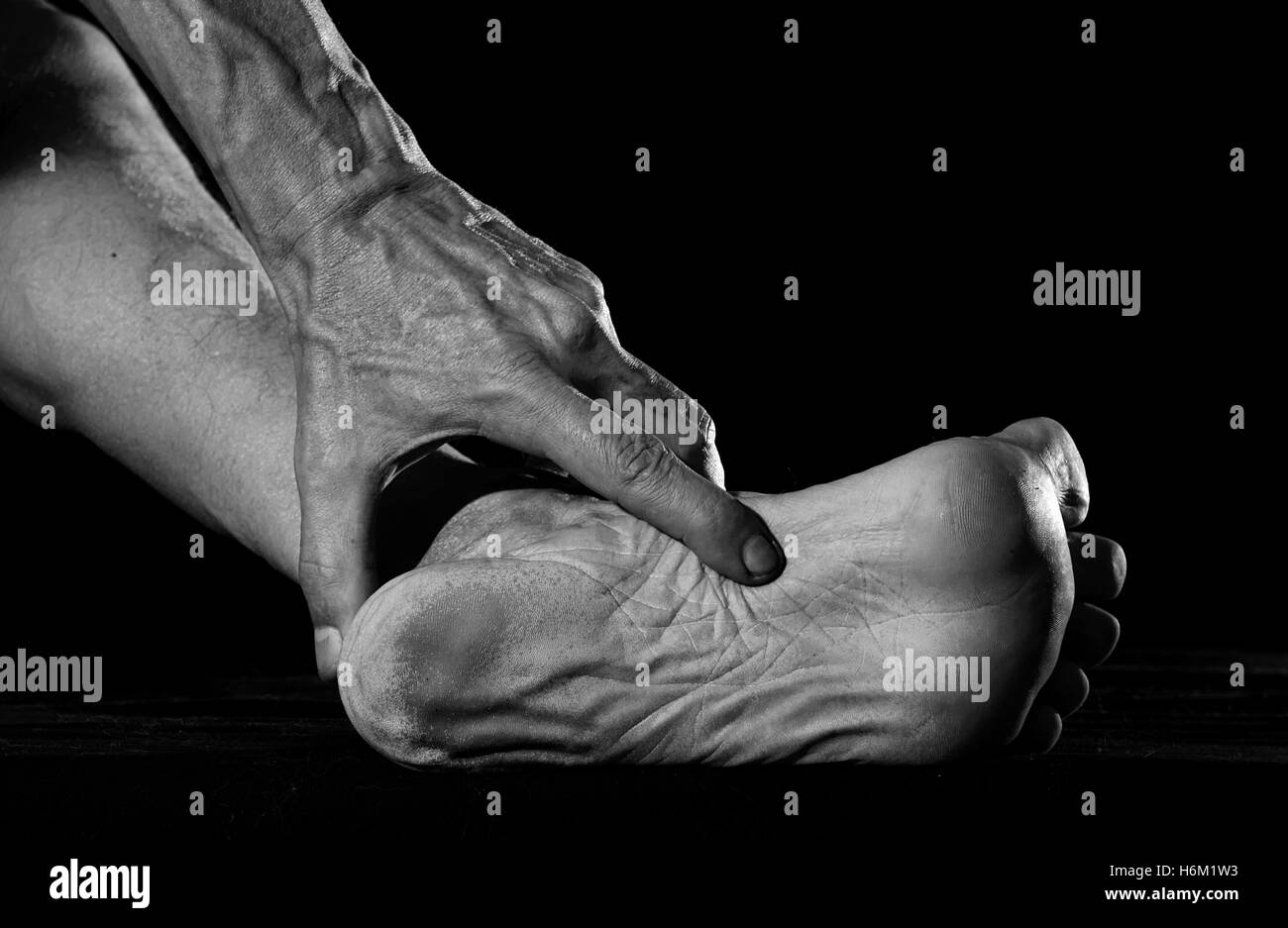 Dirty hand searches splinter stuck in dirty foot Stock Photo - Alamy