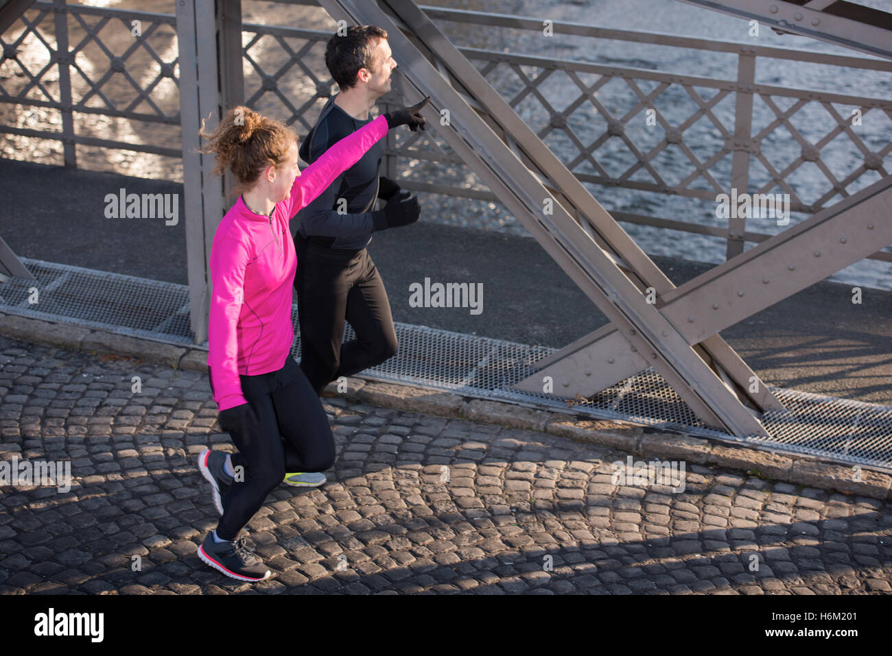 healthy young couple jogging in the city at early morning with sunrise ...