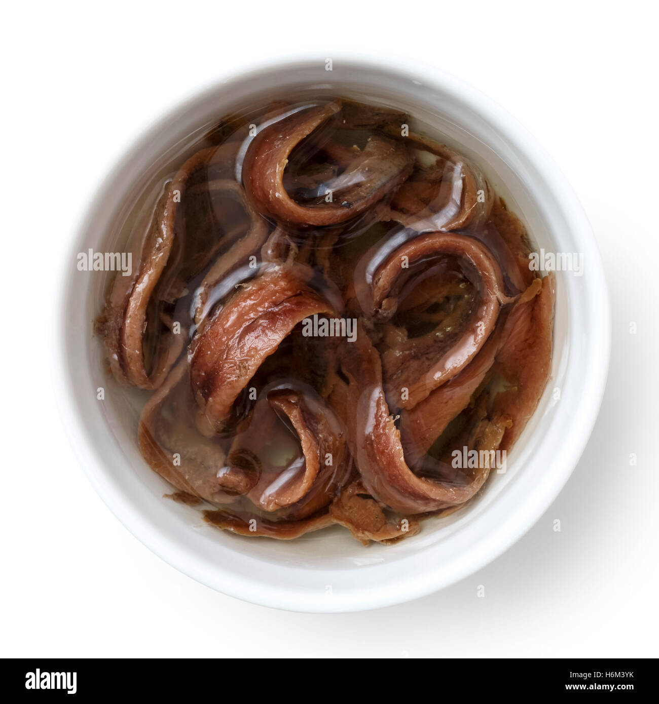 Anchovy fillets in oil in a white bowl isolated from above on white ...