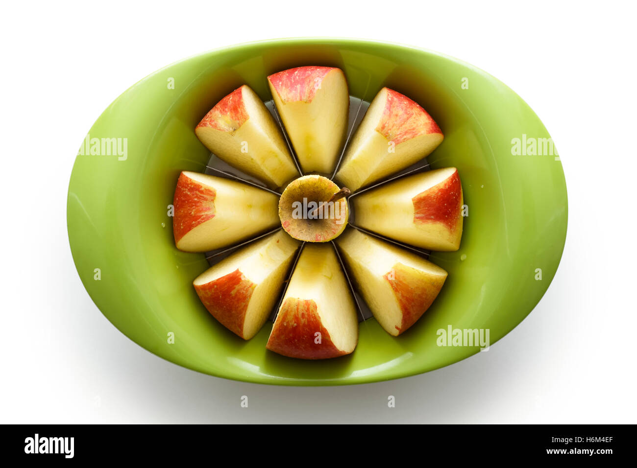 Green apple slicer with sliced apple segments from above, isolated on ...