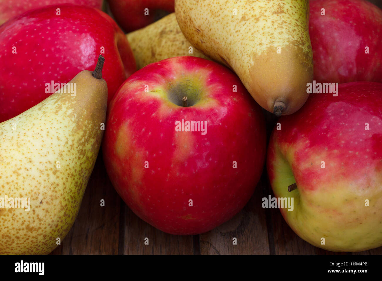 Mixed red apples and pears attractively arranged on dark wood Stock ...
