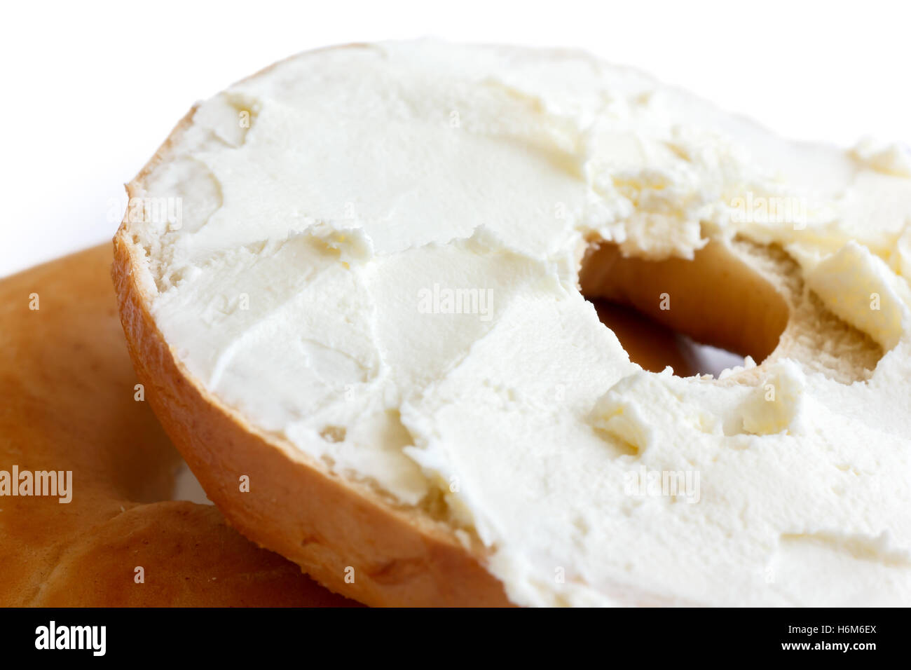 Plain bagel cut in half and spread with cream cheese, detail Stock ...