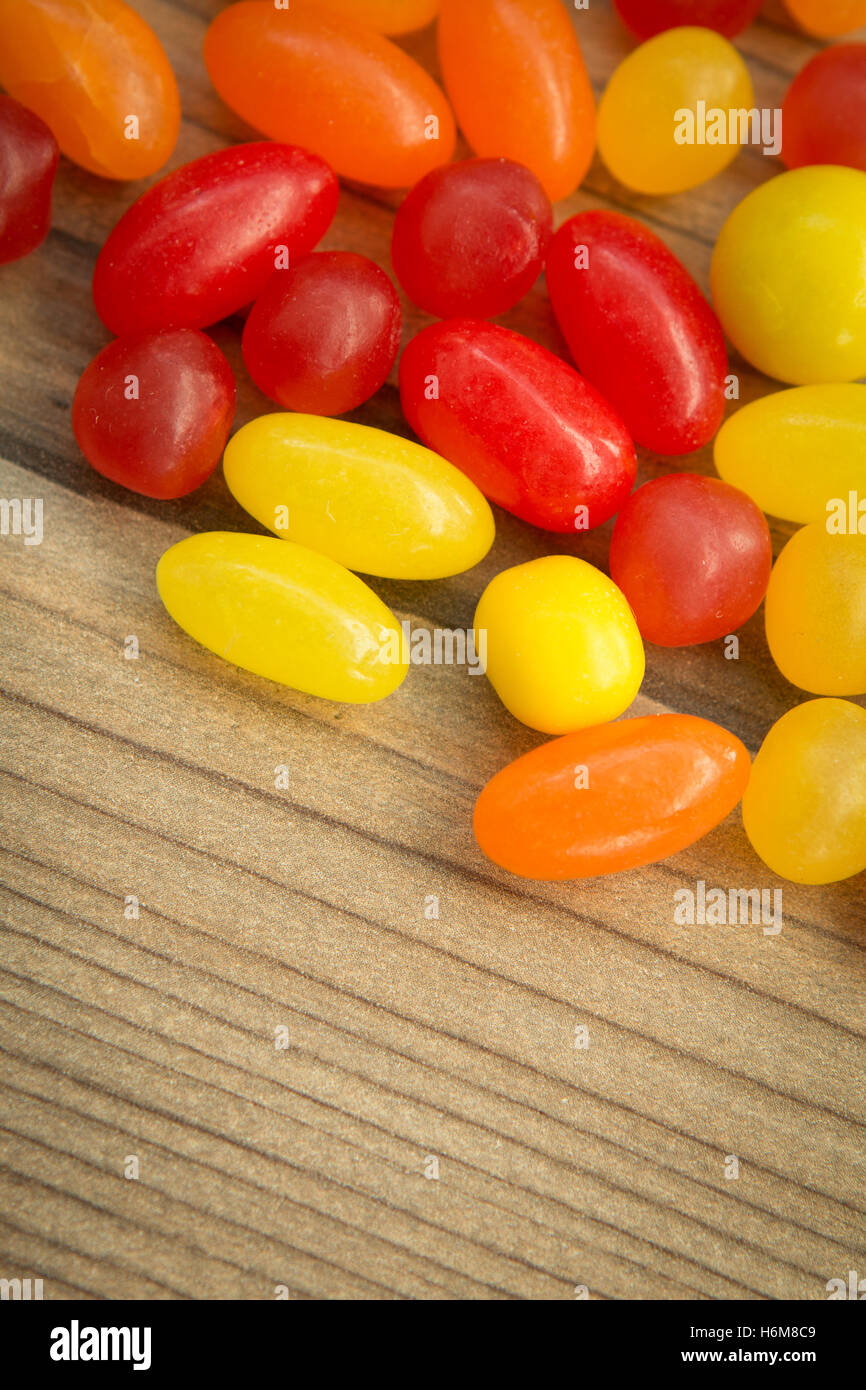Colorful jelly beans shaped a frame to write your text on a wooden ...