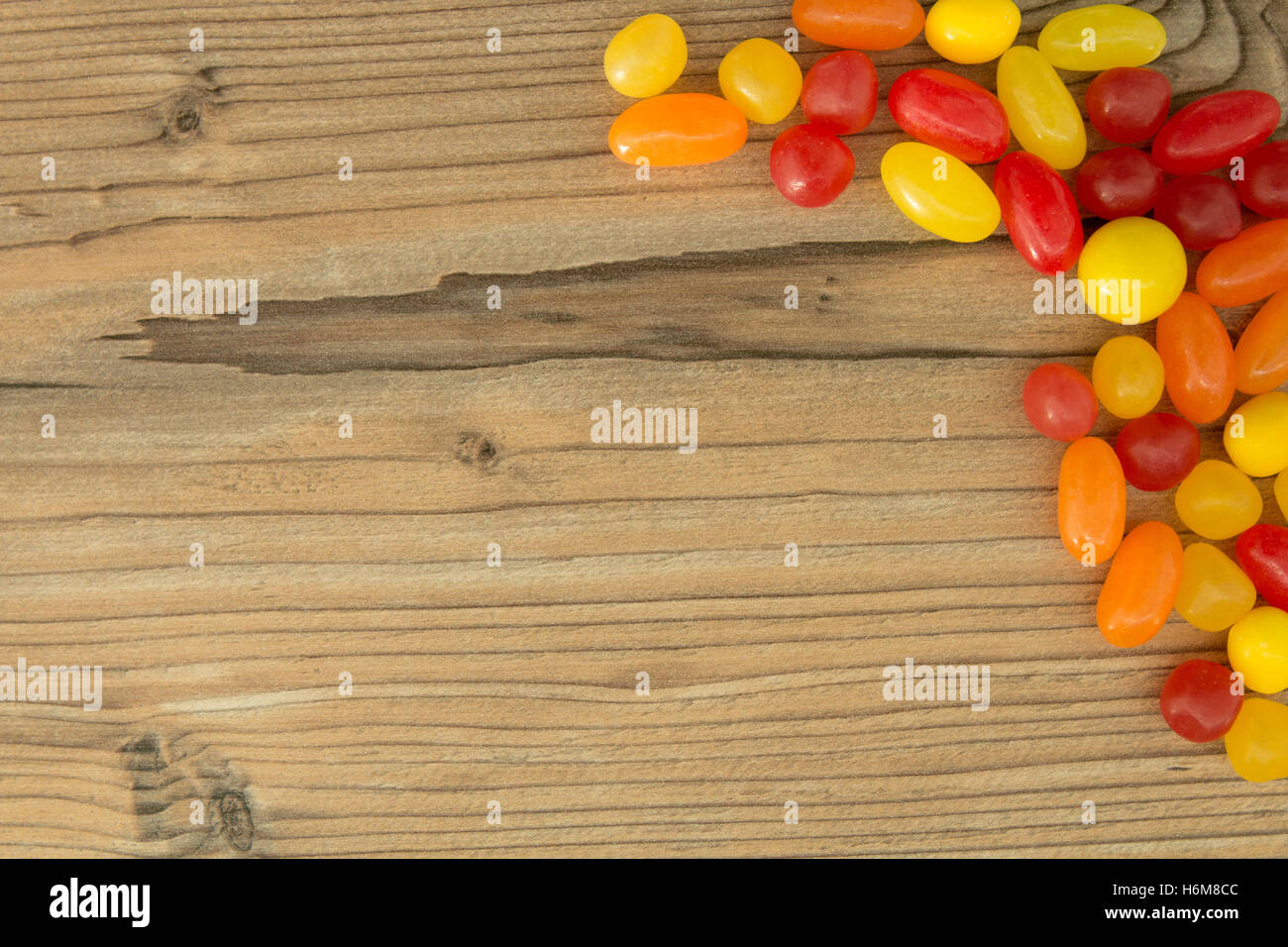 Colorful jelly beans shaped a frame to write your text on a wooden ...