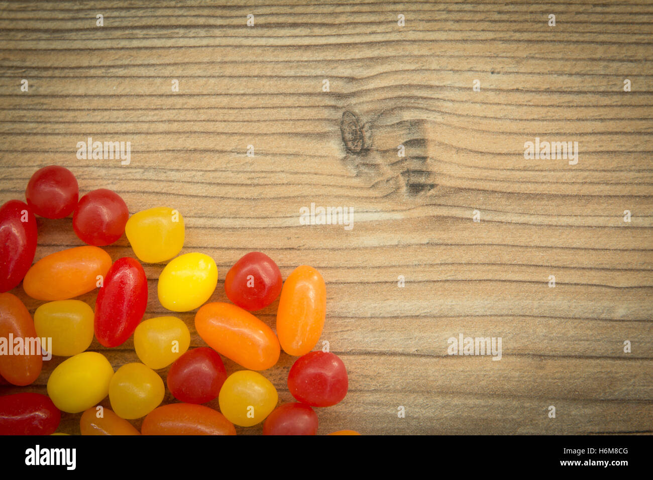 Colorful jelly beans shaped a frame to write your text on a wooden ...