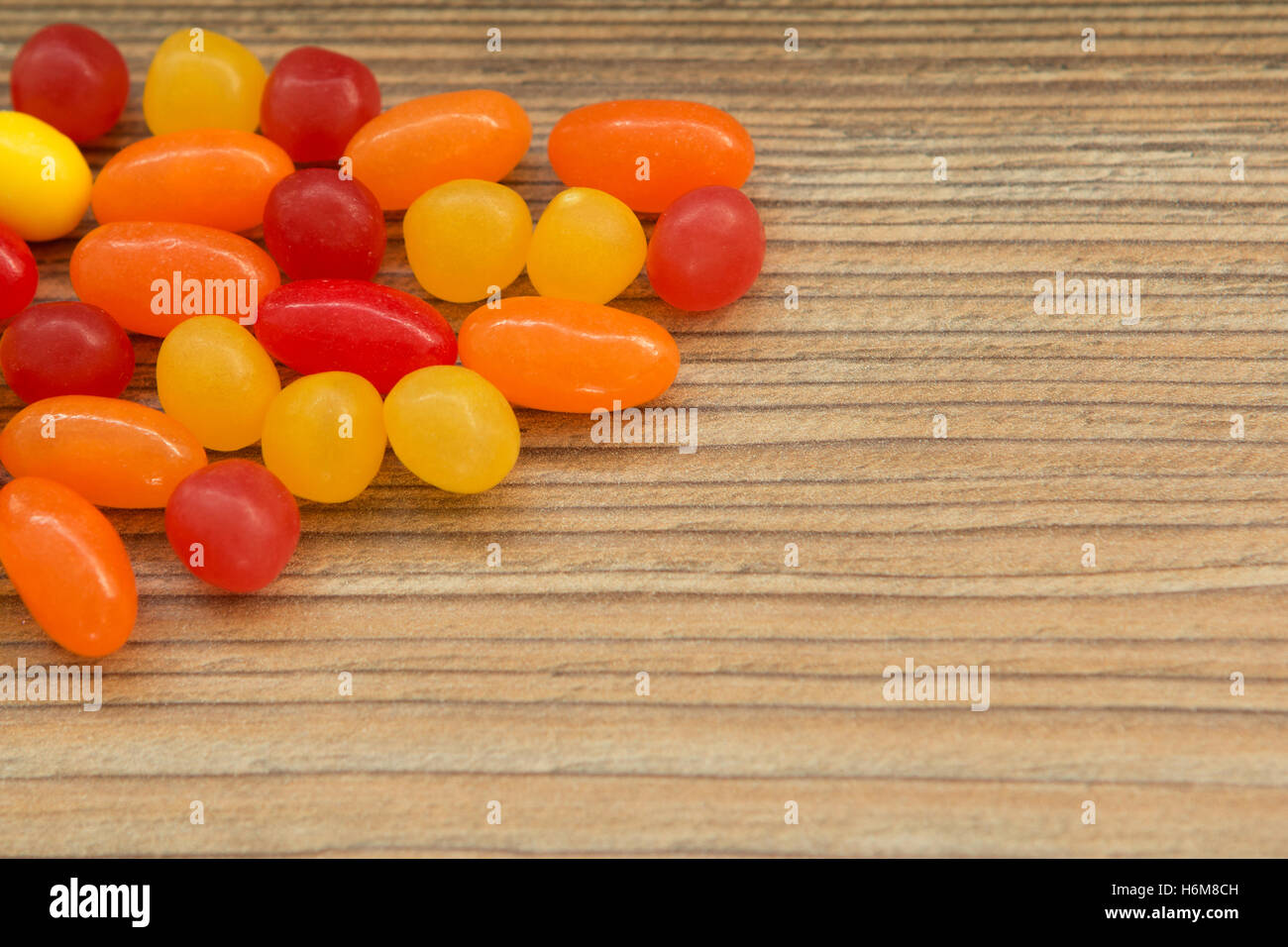 Colorful jelly beans shaped a frame to write your text on a wooden ...