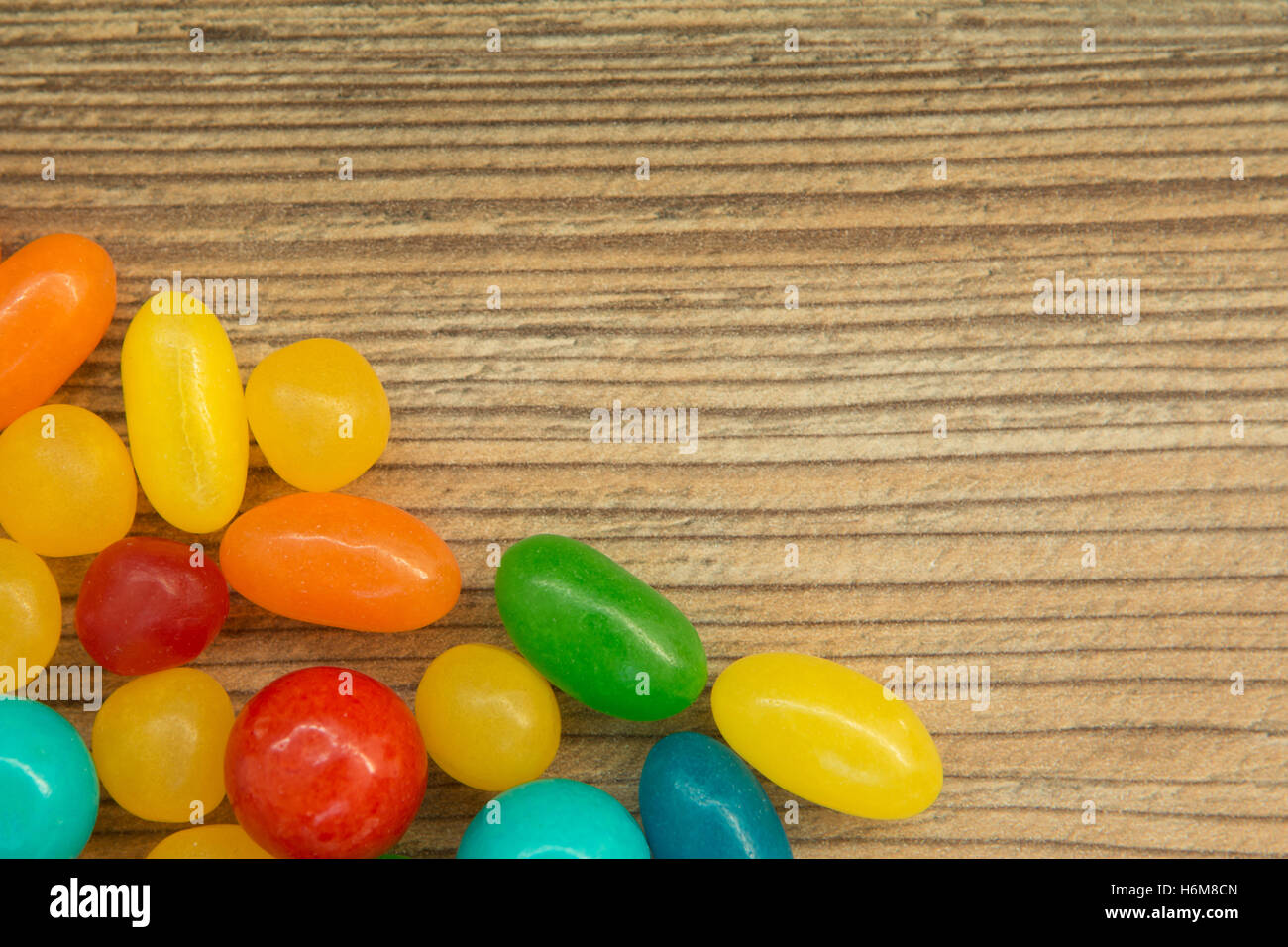Colorful jelly beans shaped a frame to write your text on a wooden ...