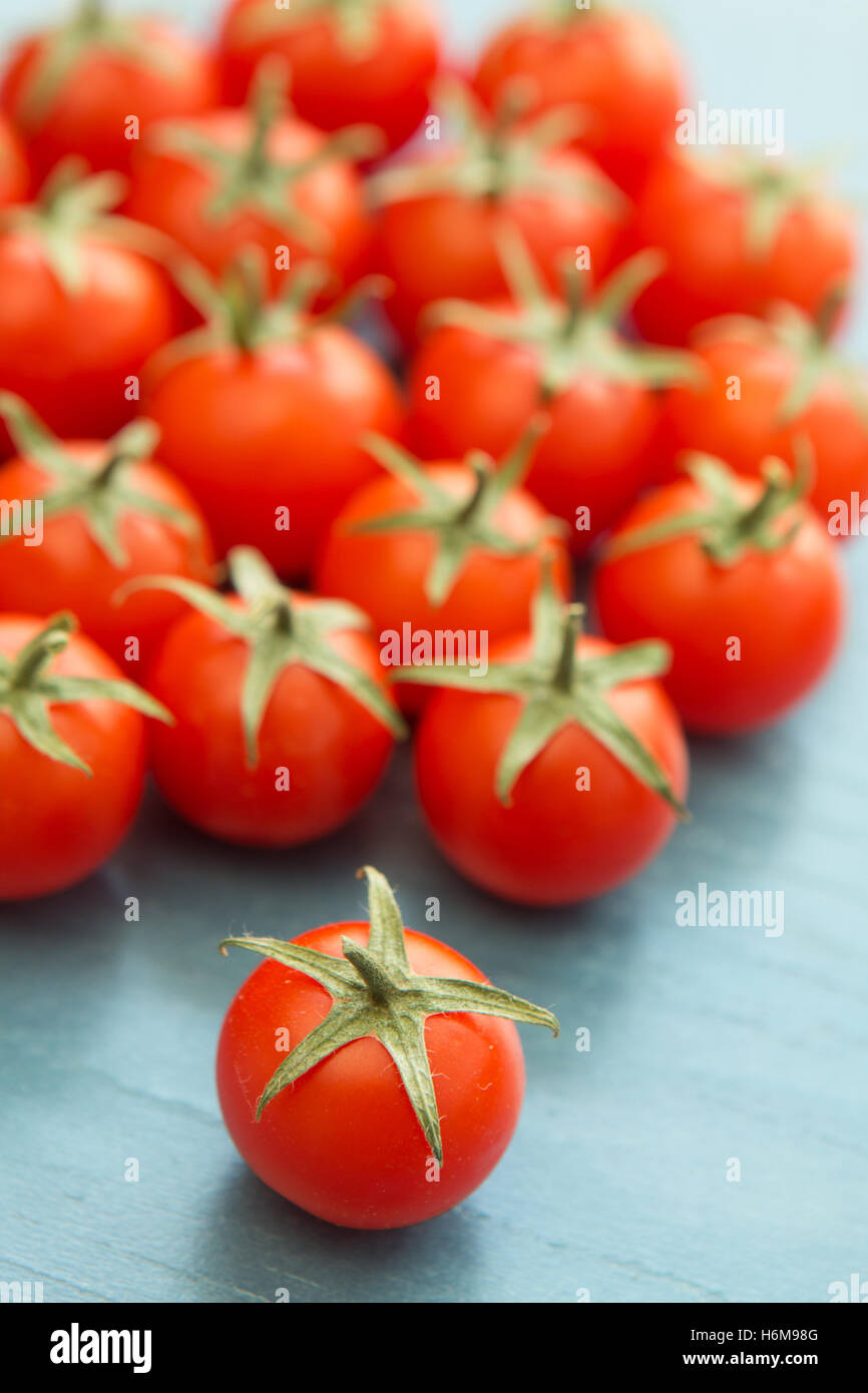 Small cherry tomatoes with leaf on a blue wooden surface Stock Photo ...