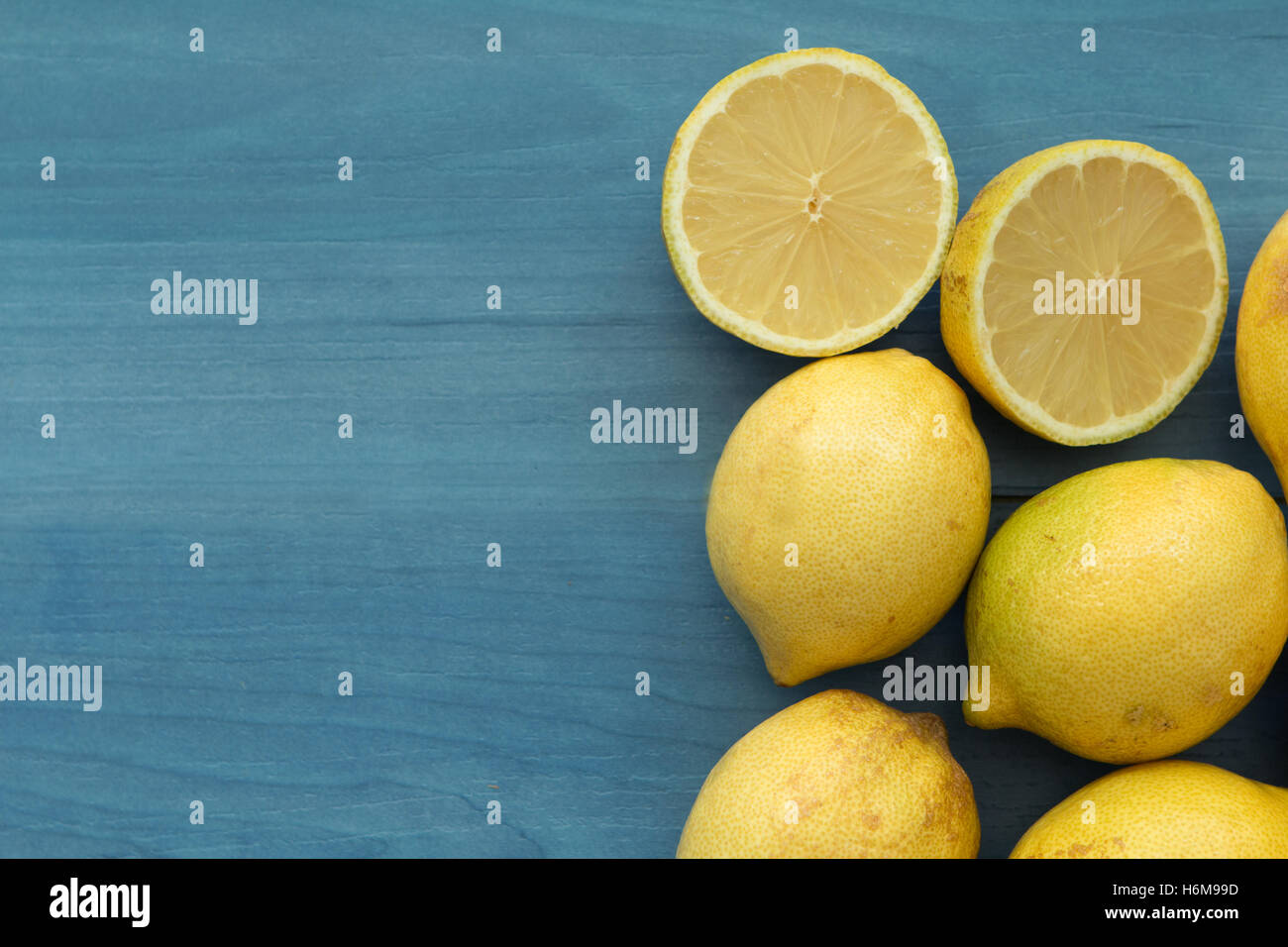 Acid and yellow fruit. Lemons on a blue wood Stock Photo - Alamy