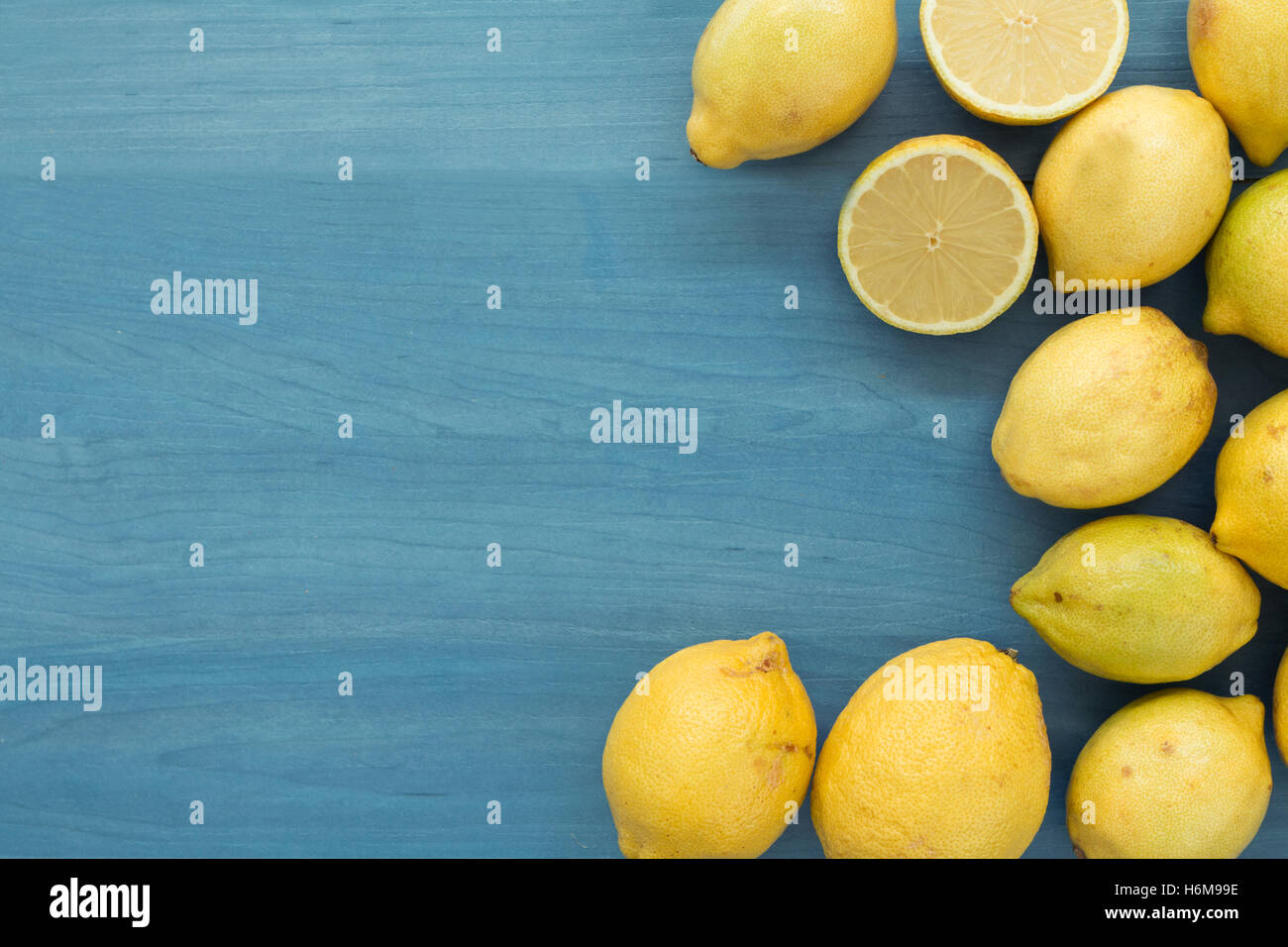 Acid and yellow fruit. Lemons on a blue wood Stock Photo - Alamy