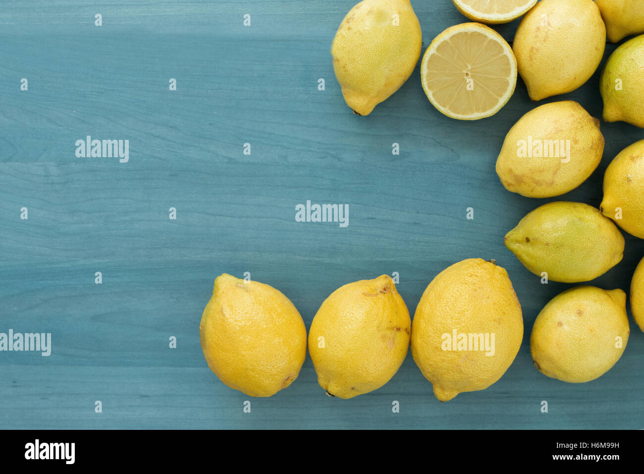 Acid and yellow fruit. Lemons on a blue wood Stock Photo - Alamy