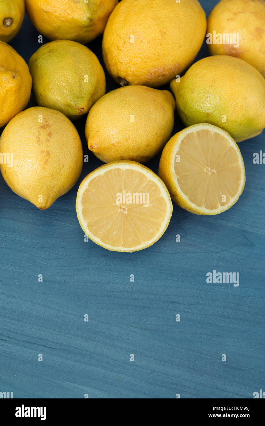 Acid and yellow fruit. Lemons on a blue wood Stock Photo - Alamy