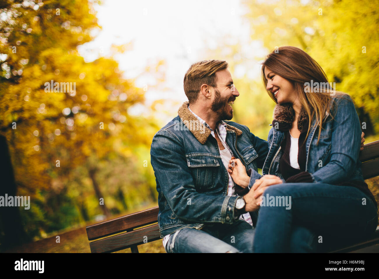 Loving and romantic couple on a bench in the autumn park Stock Photo ...