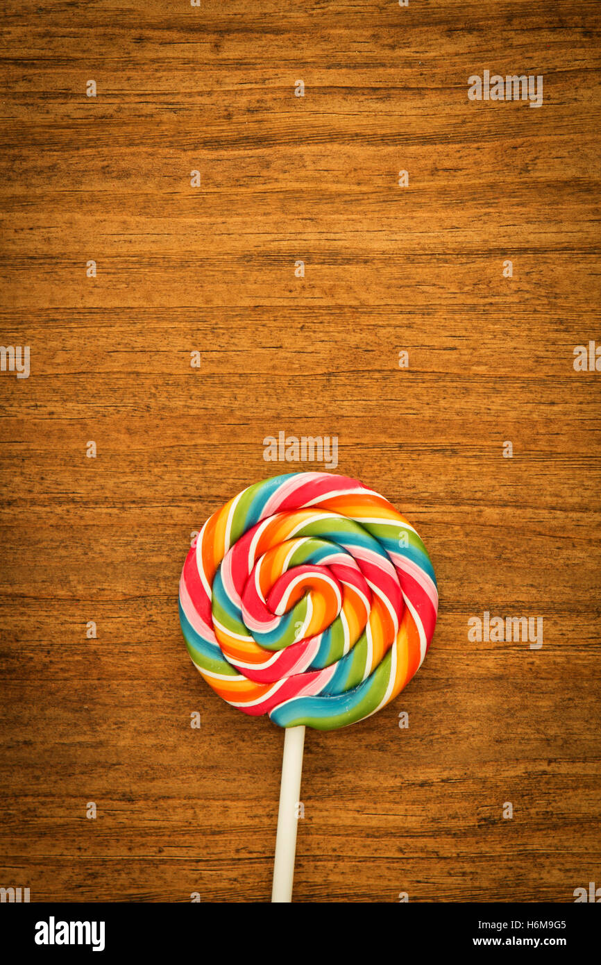 Nice lollipop with many colors in a spiral on a wooden background Stock ...