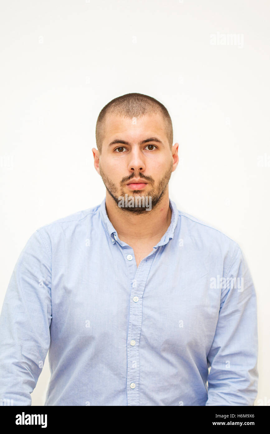 Portrait of a man in front of the white wall Stock Photo - Alamy