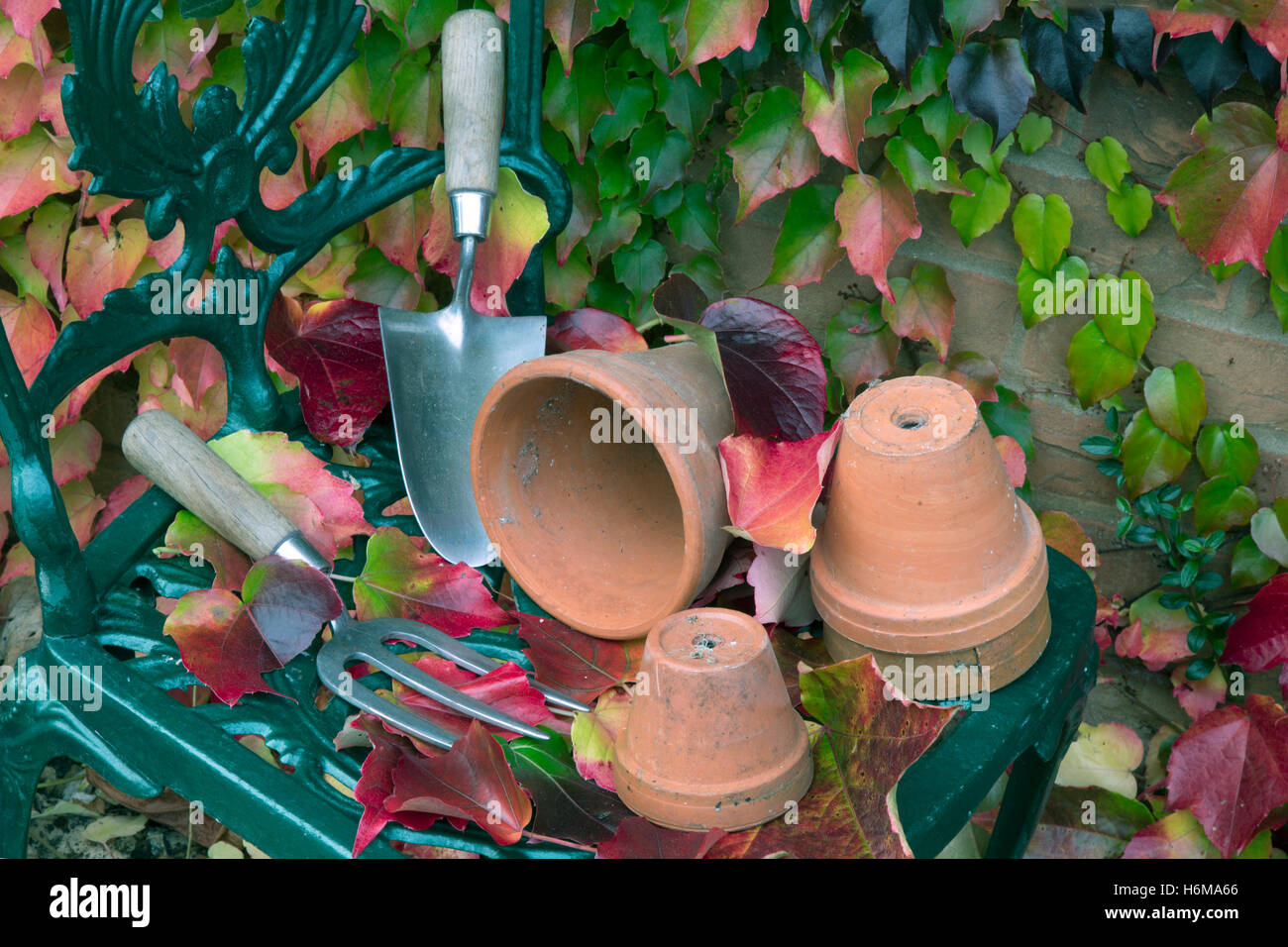 Garden hand tools and terra cotta flower pots with fallen leaves of ...