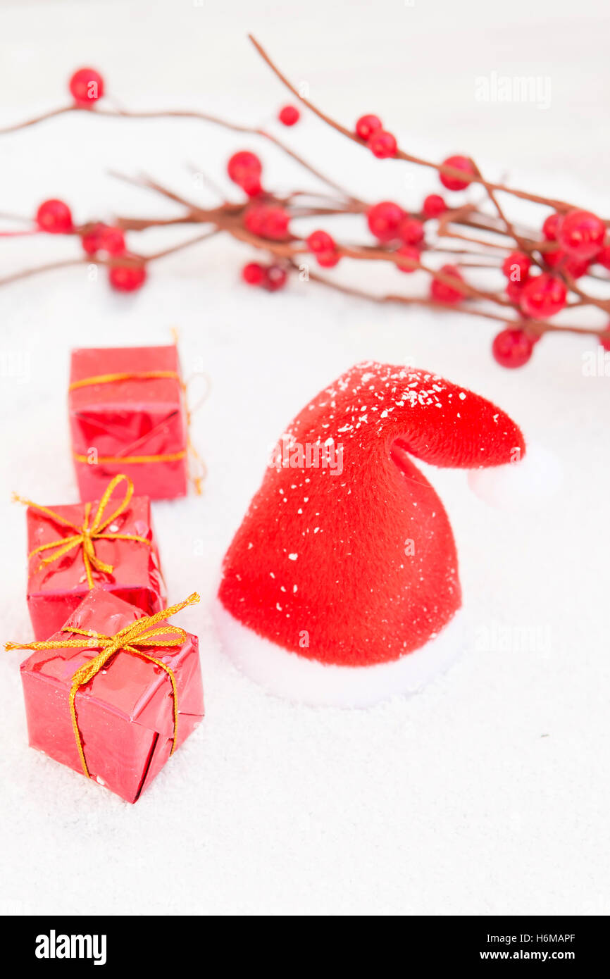 Santa hat on snow with some gifts. Christmas in red Stock Photo - Alamy