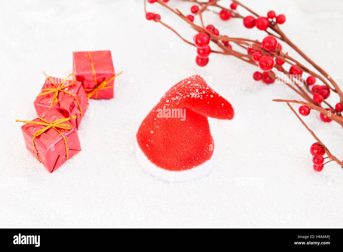 Santa hat on snow with some gifts. Christmas in red Stock Photo - Alamy