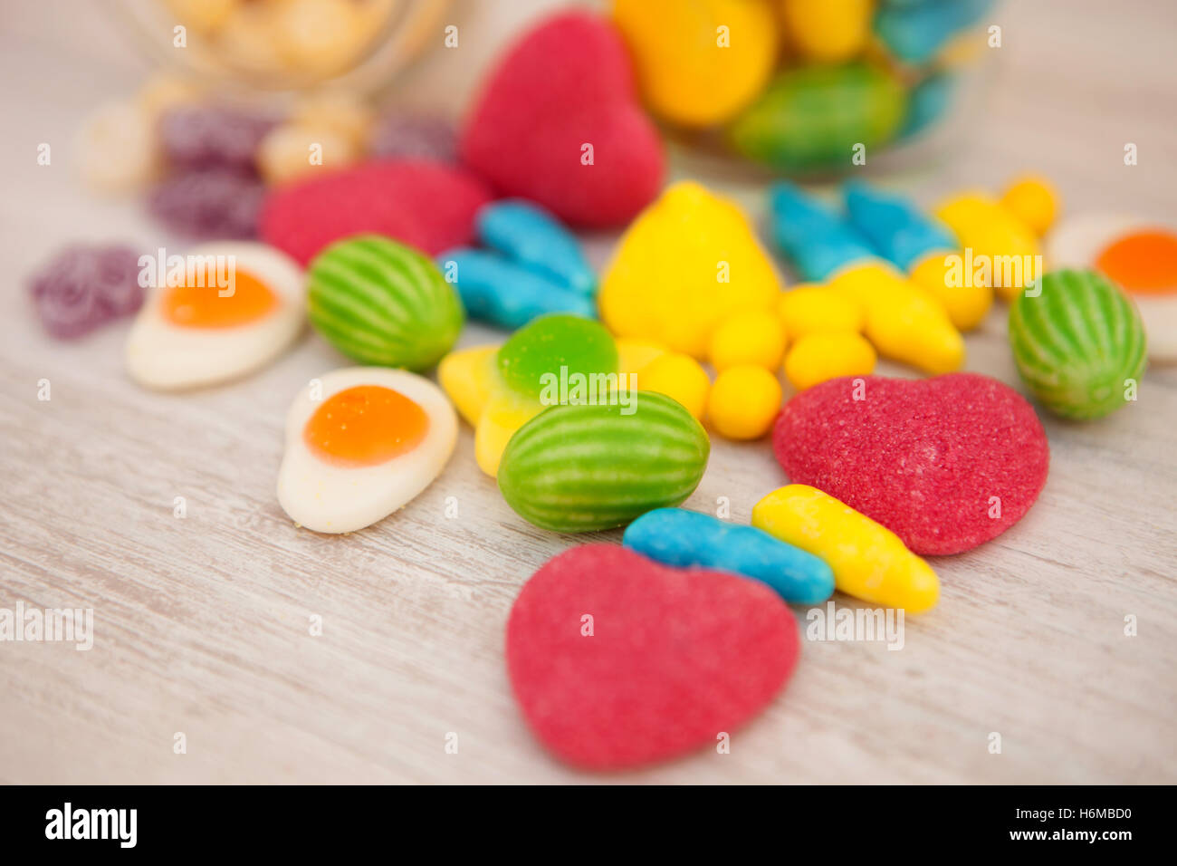 Candies with different shapes and colors on a gray wooden background ...