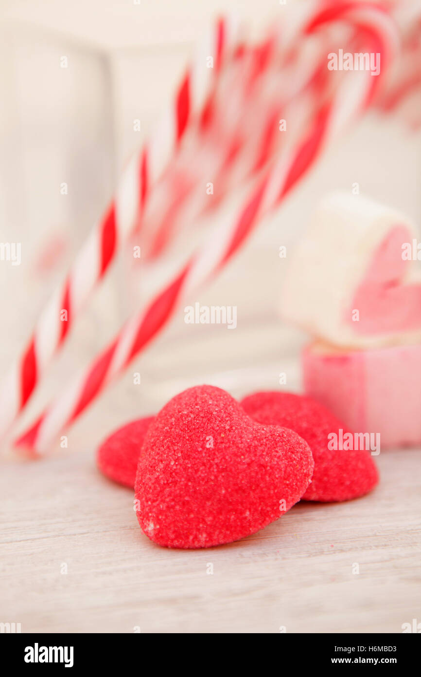 Candy canes and heart-shaped candies on a wooden grey background. Soft ...