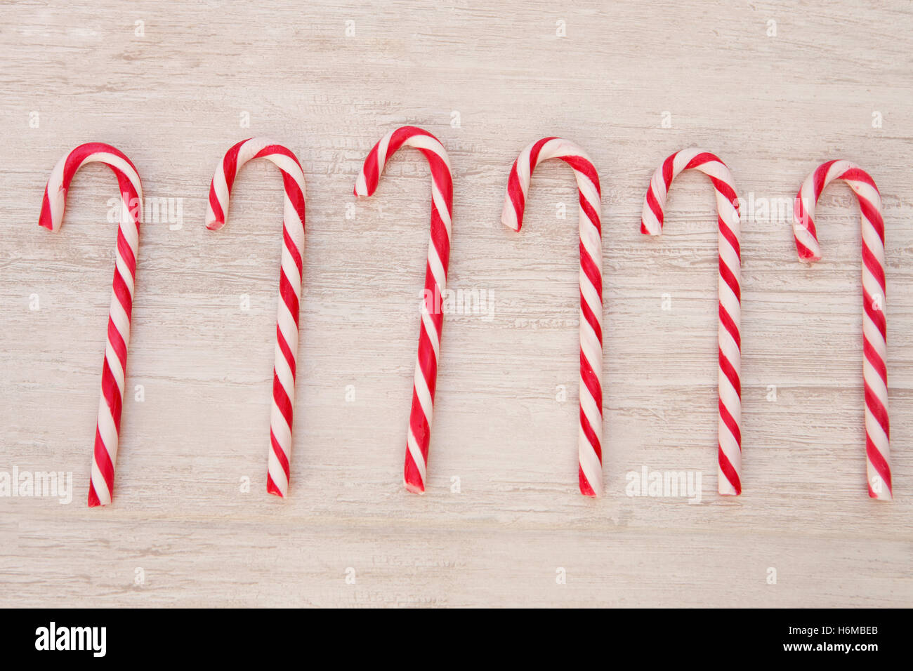 Red and white candy canes on a gray wooden background Stock Photo - Alamy
